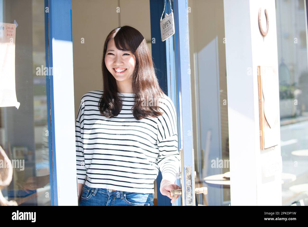 Woman laughing in front of a store Stock Photo - Alamy