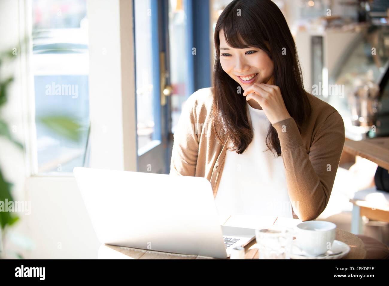 Woman working at a café using a computer Stock Photo - Alamy
