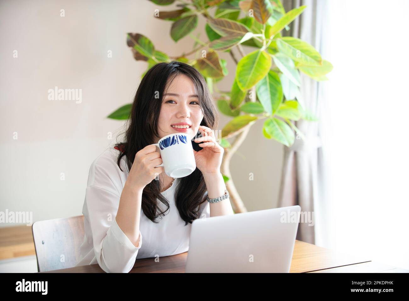 Woman laughing in front of computer Stock Photo - Alamy