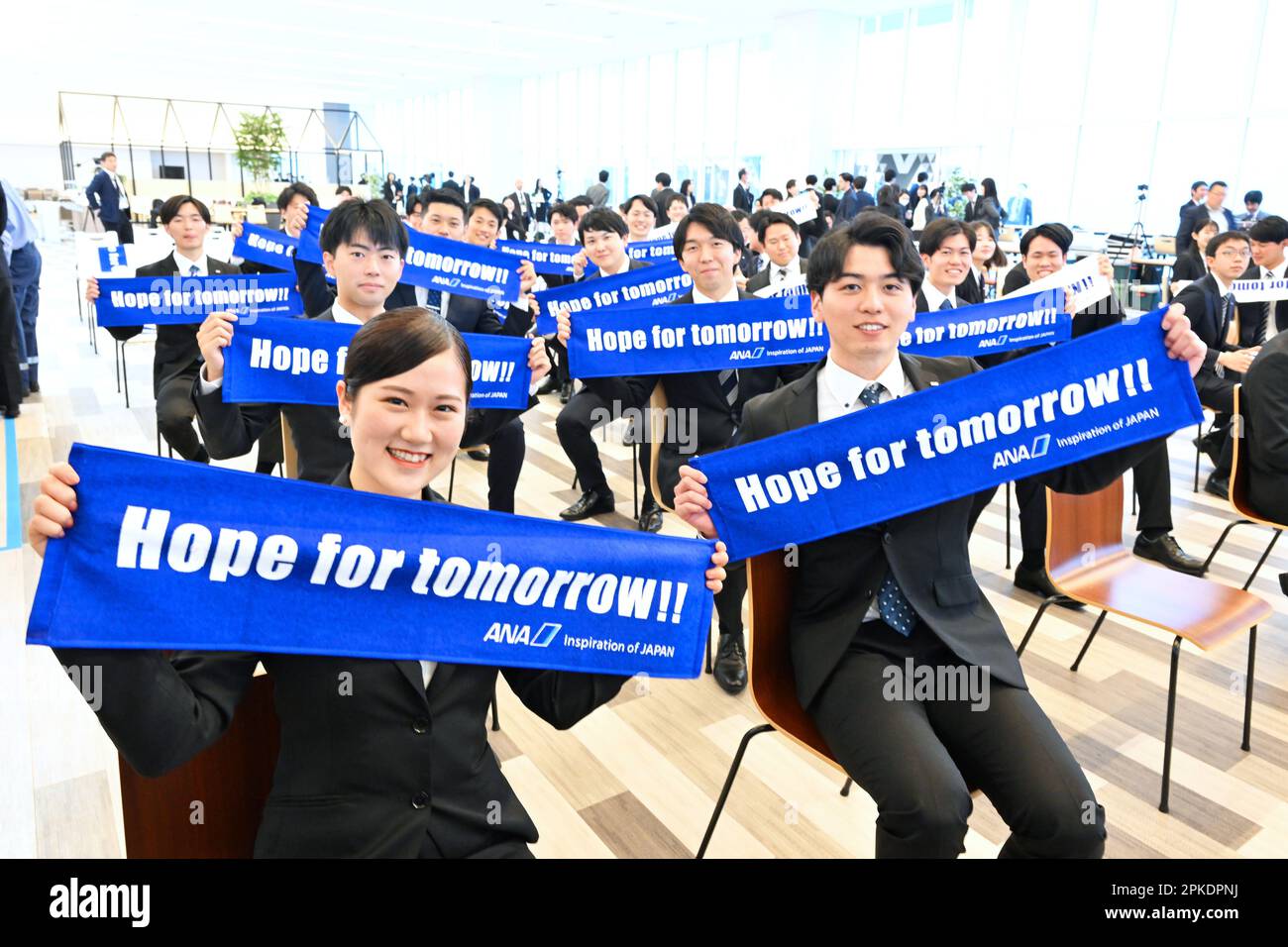 New employees hold the customary blue towels during the ANA Group ...