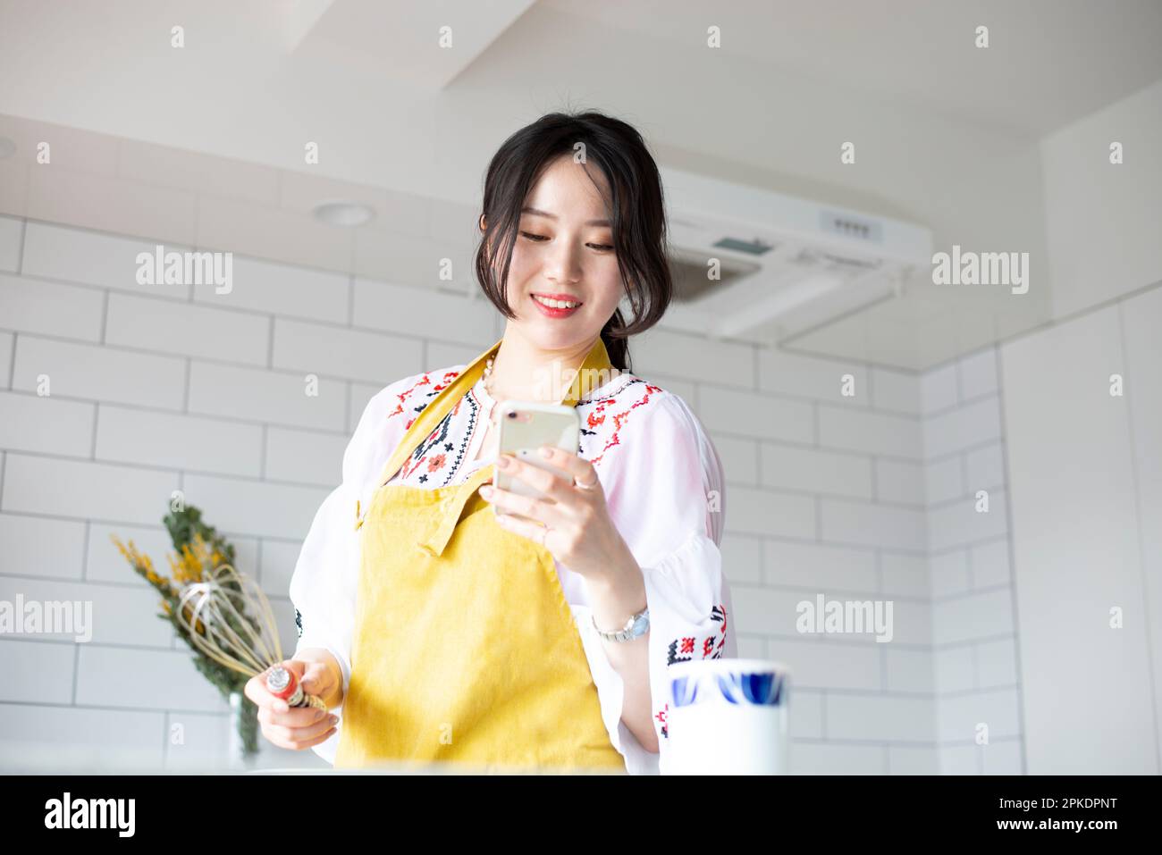 Cooking woman looking smartphone in hi-res stock photography and images ...