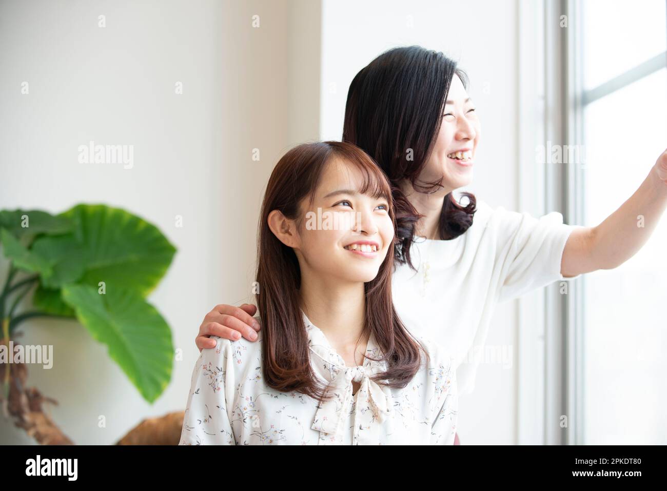 Parent and child looking out the window Stock Photo - Alamy