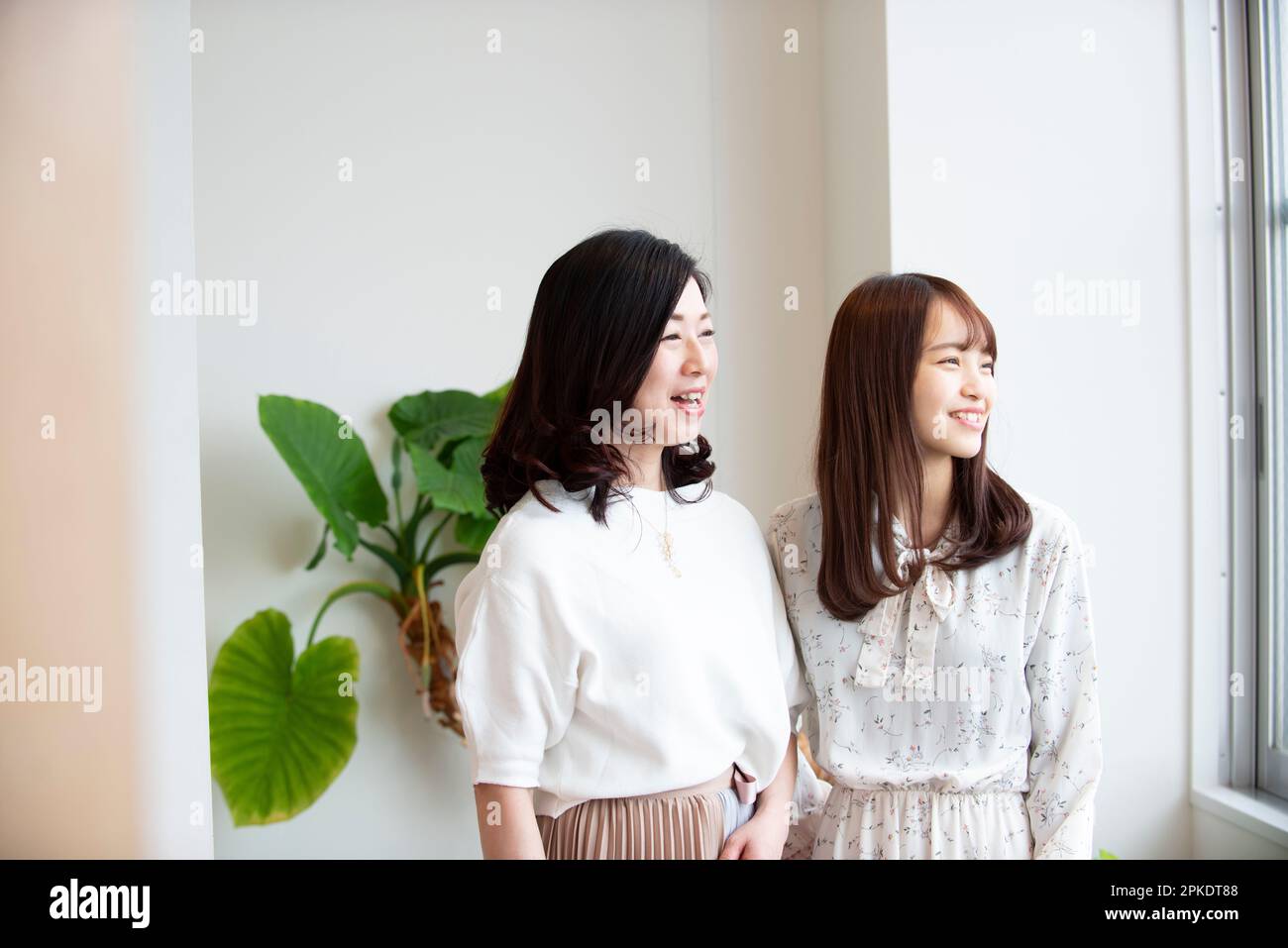 Parent and child looking out the window Stock Photo - Alamy