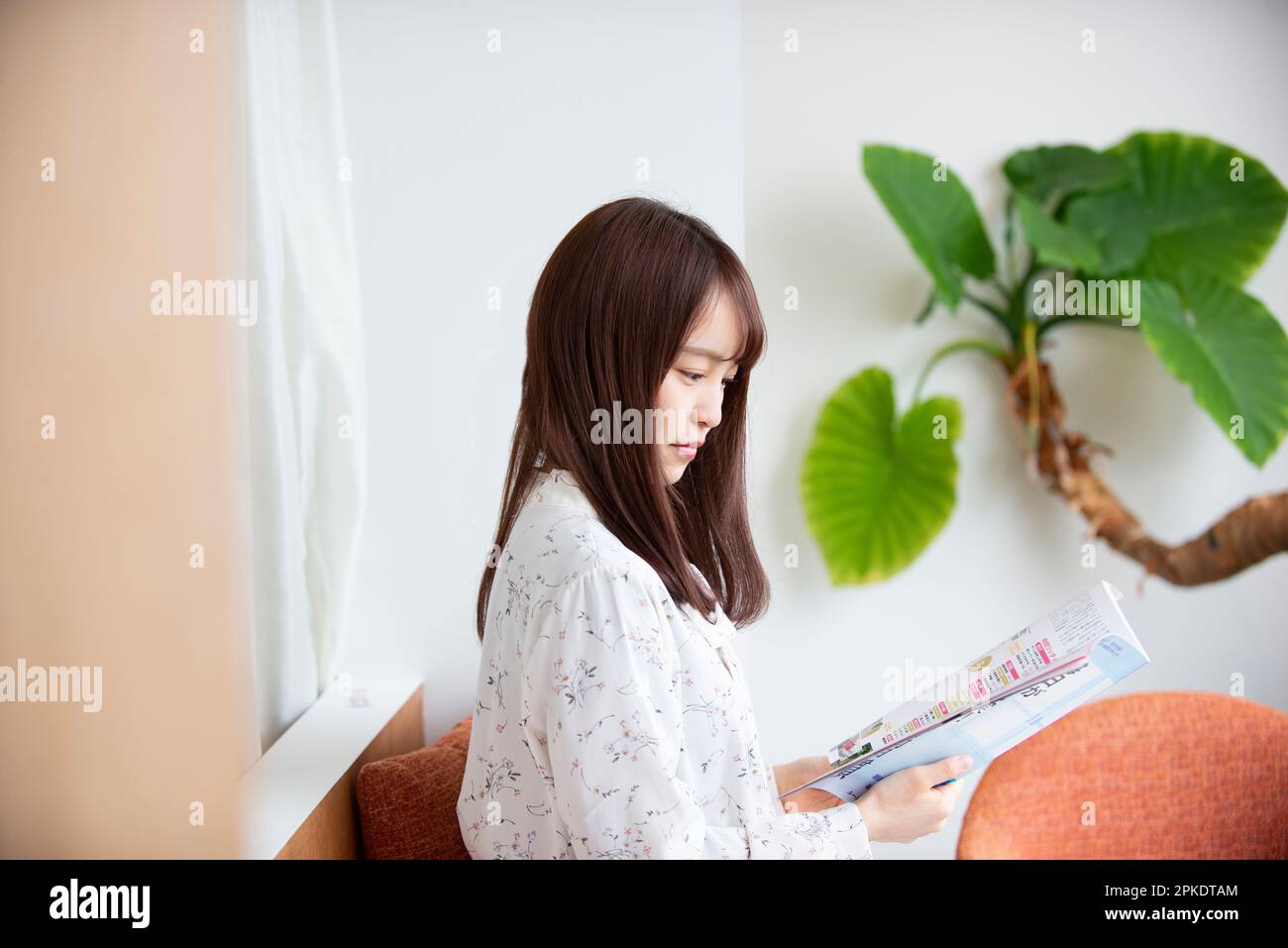 Woman reading a magazine in the waiting room Stock Photo - Alamy