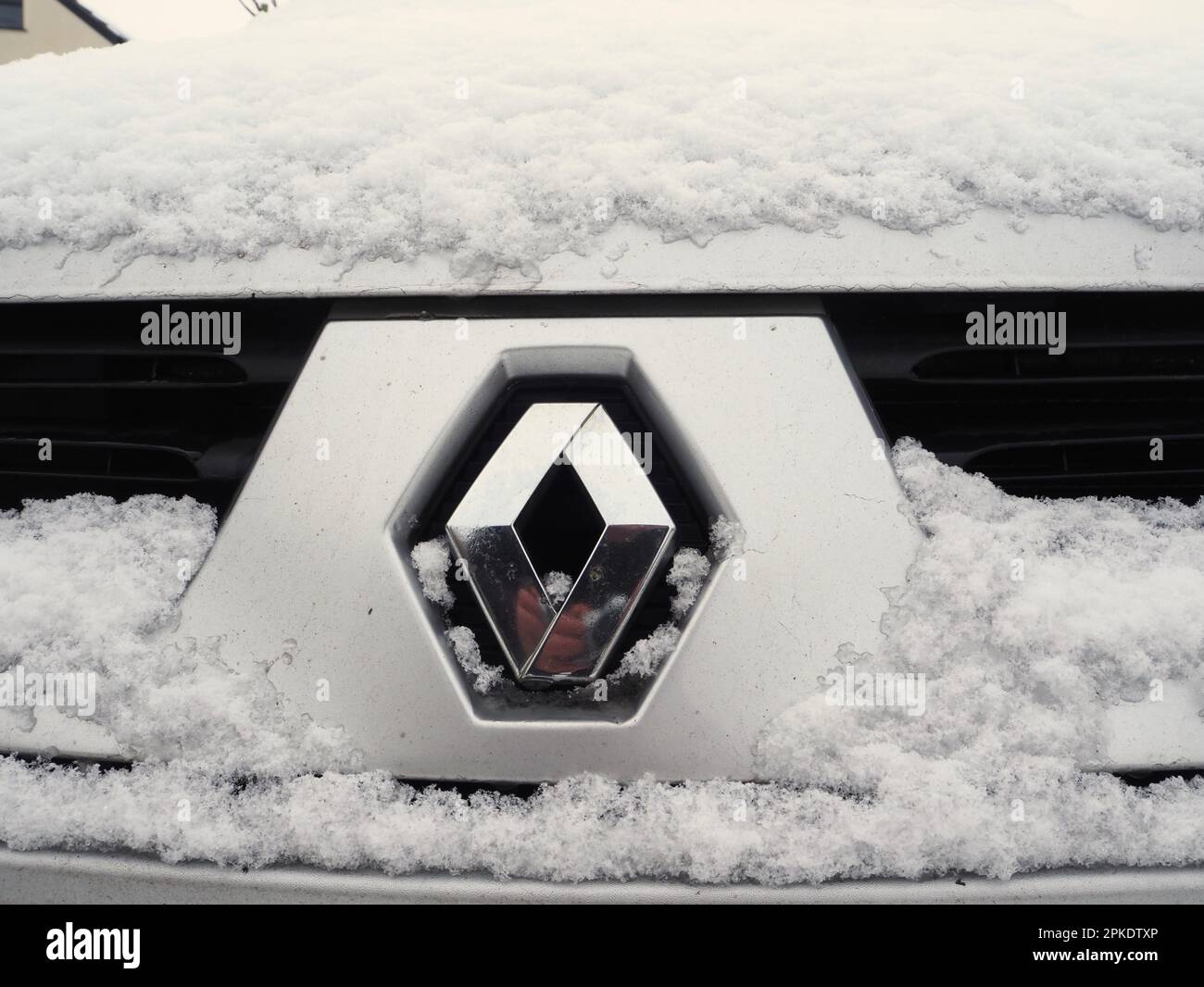 Front end of a Renault car, covered in snow, showing the brand badge ...