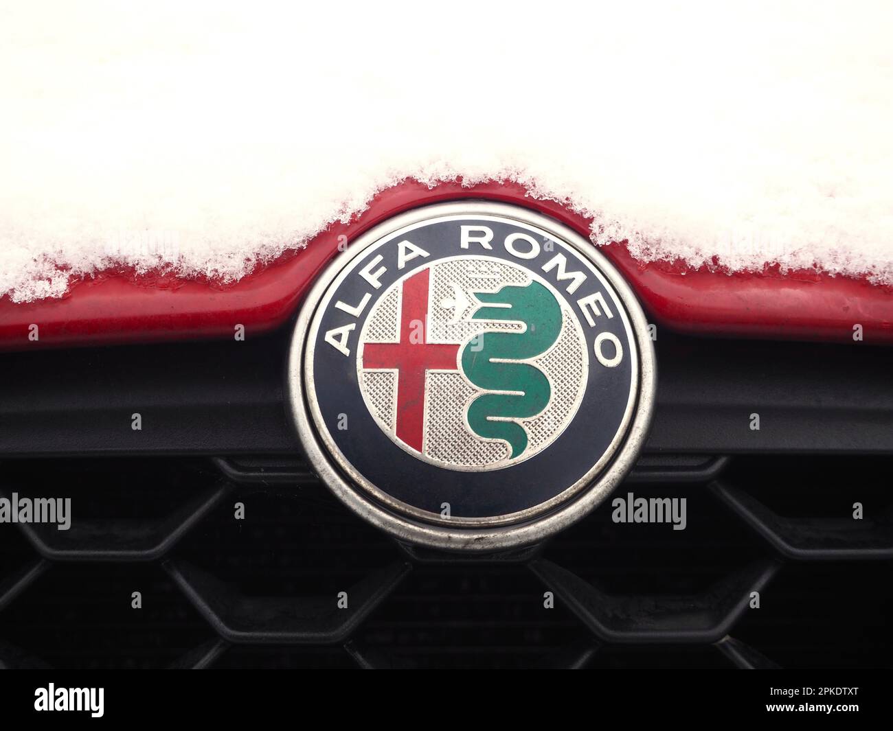 Front end of an Alfa Romeo car, covered in snow, showing the brand ...