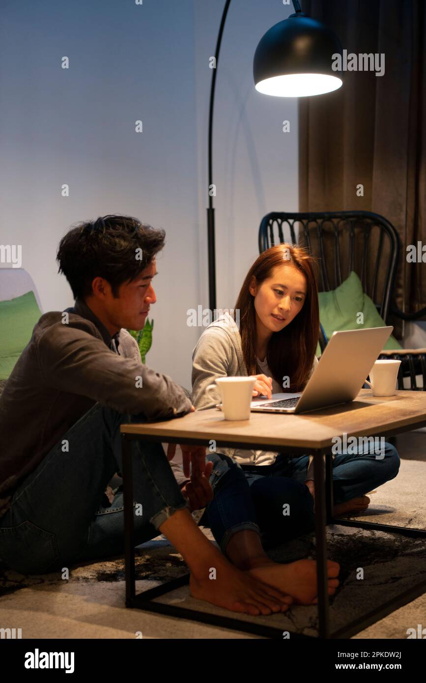 Couple watching computer together in the living room Stock Photo - Alamy