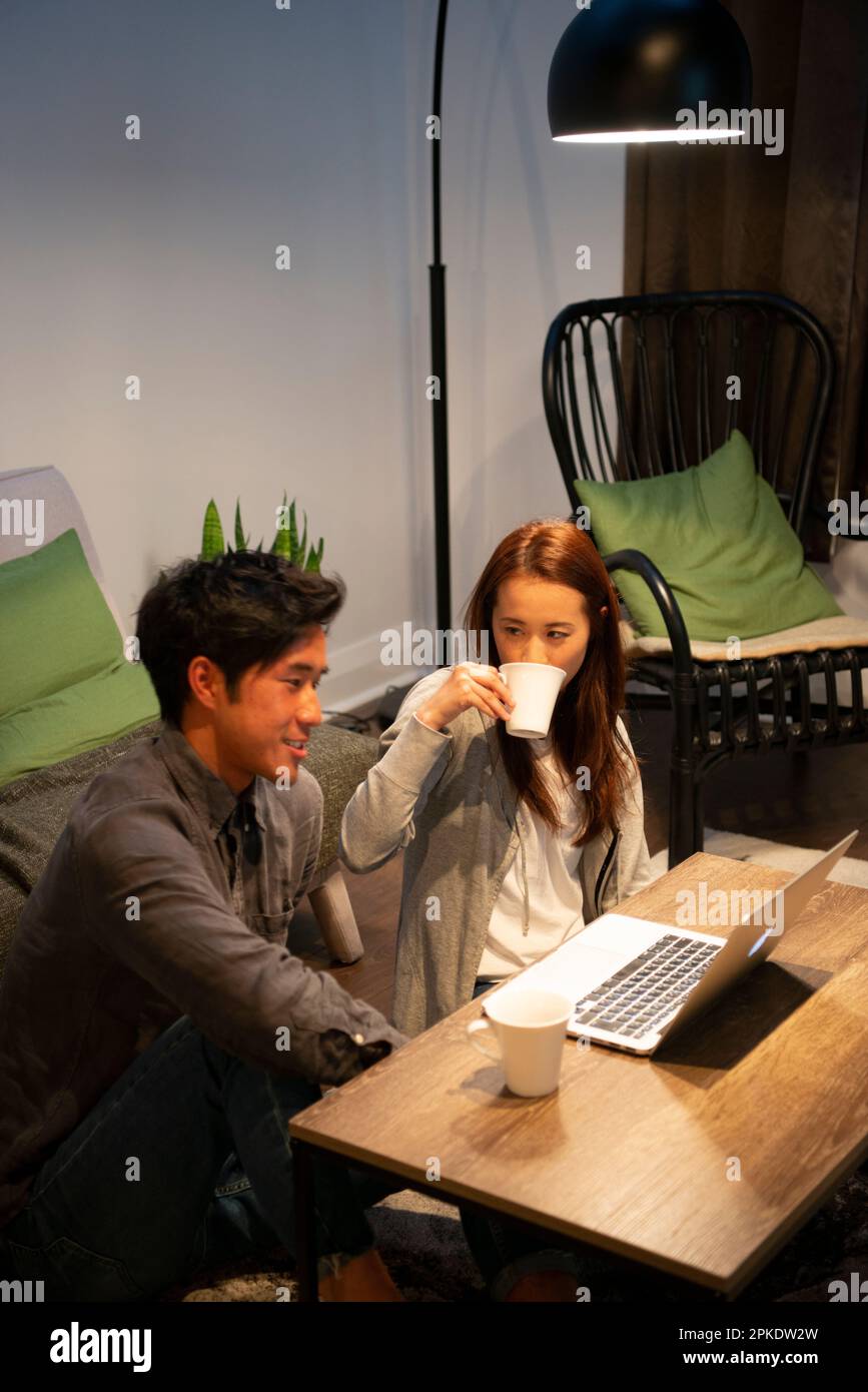 Couple watching computer together in living room Stock Photo - Alamy