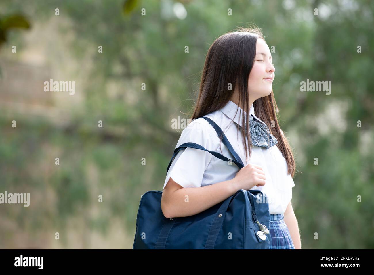 Schoolgirl in school uniform with her eyes closed Stock Photo - Alamy