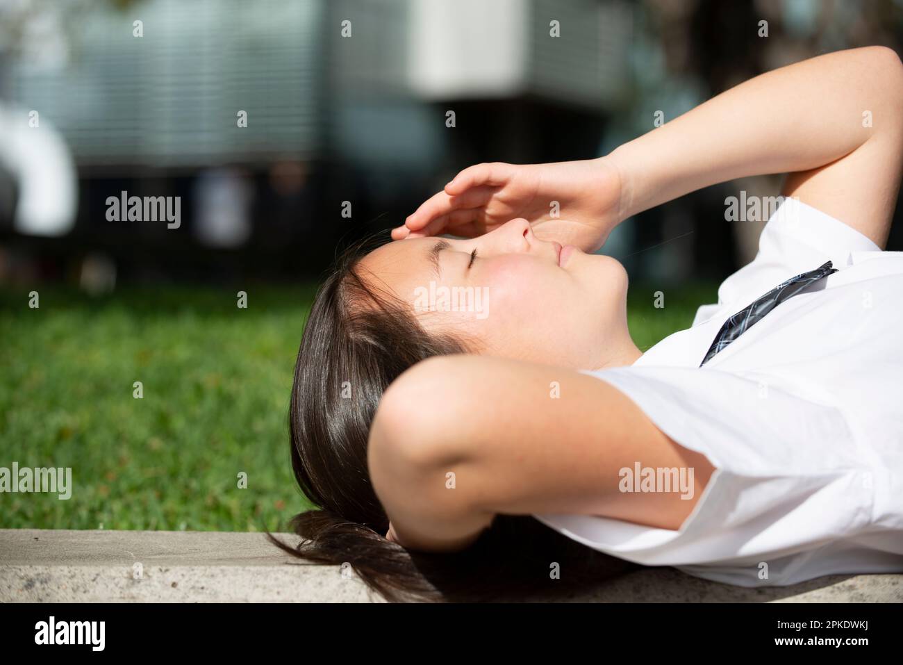 Female student in uniform lying down Stock Photo - Alamy