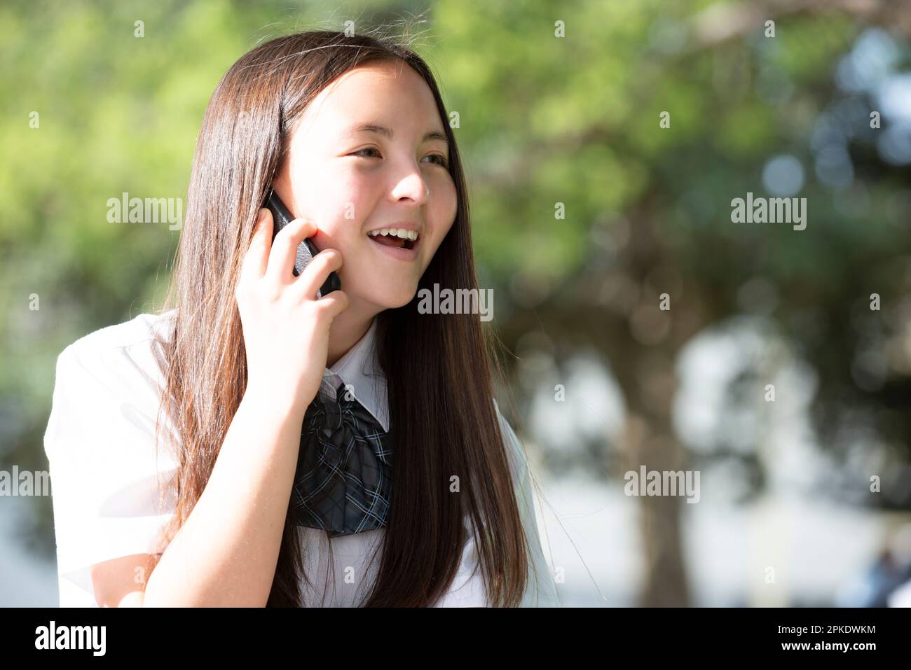 Female student in school uniform talking on the phone Stock Photo - Alamy