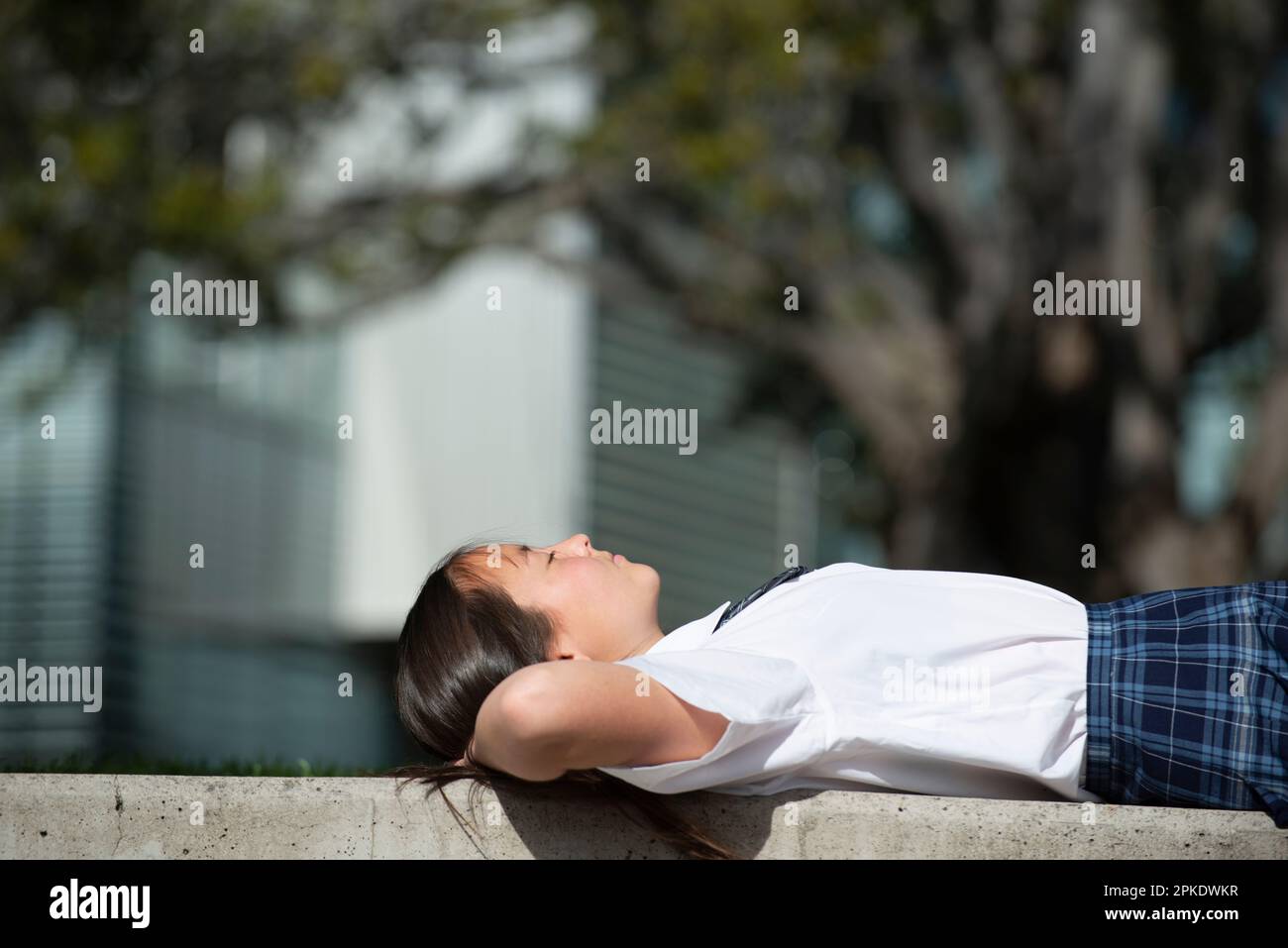 Female student in uniform lying down Stock Photo - Alamy