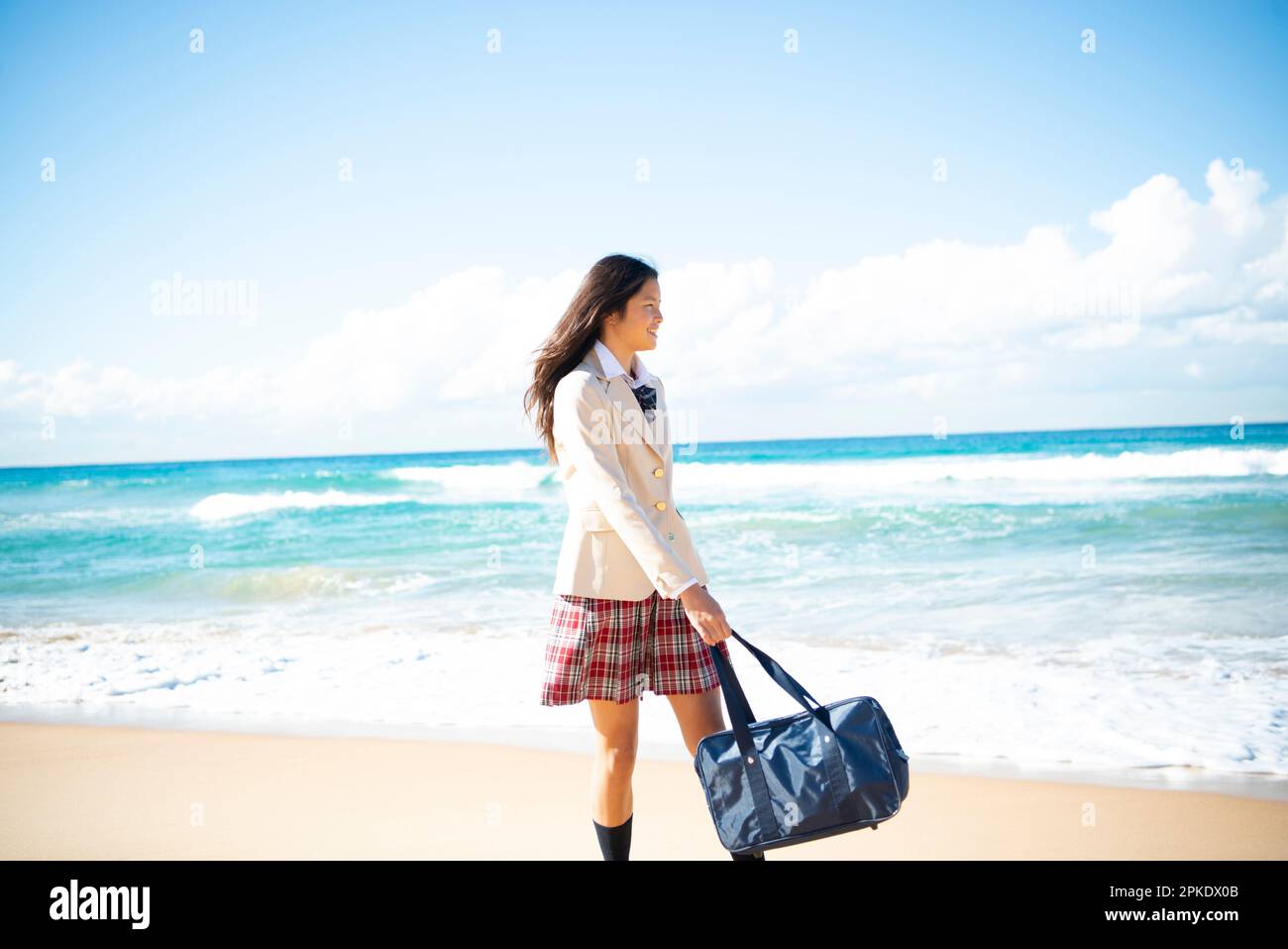 Schoolgirl in school uniform walking on the beach Stock Photo - Alamy