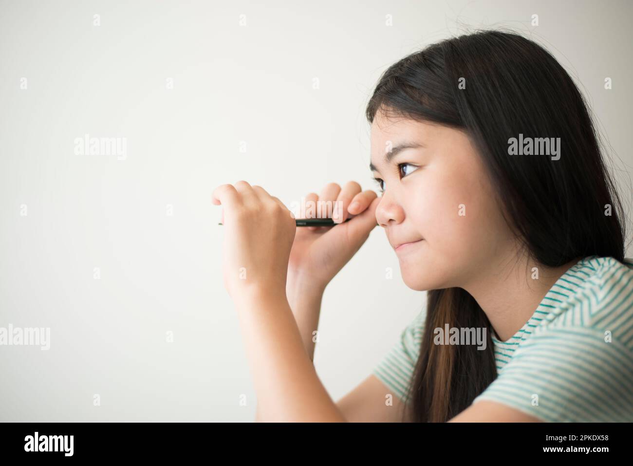 Girl thinking with pencil Stock Photo - Alamy