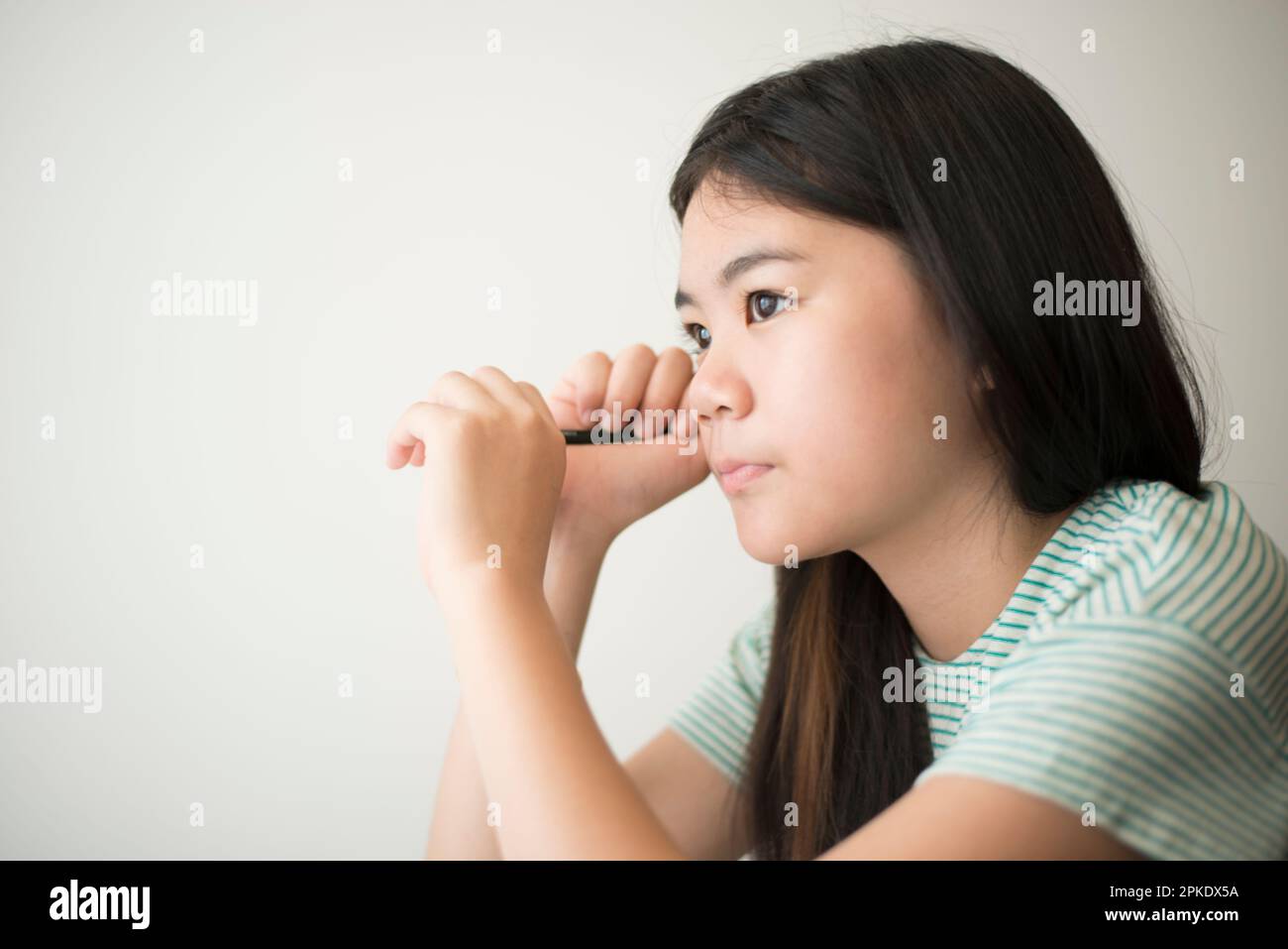 Girl thinking with pencil Stock Photo - Alamy