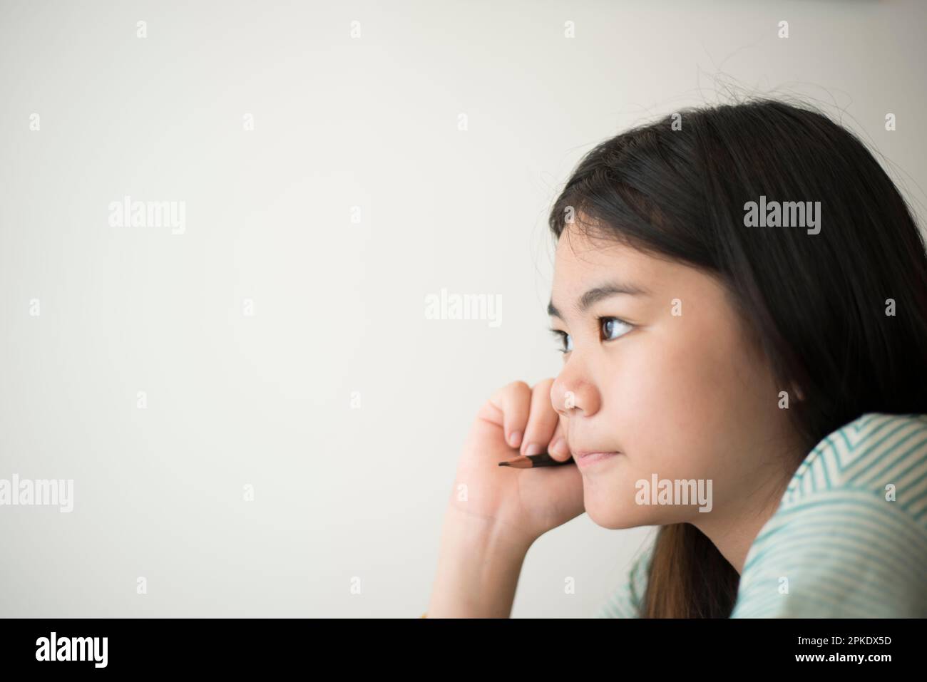 Girl thinking with pencil Stock Photo - Alamy