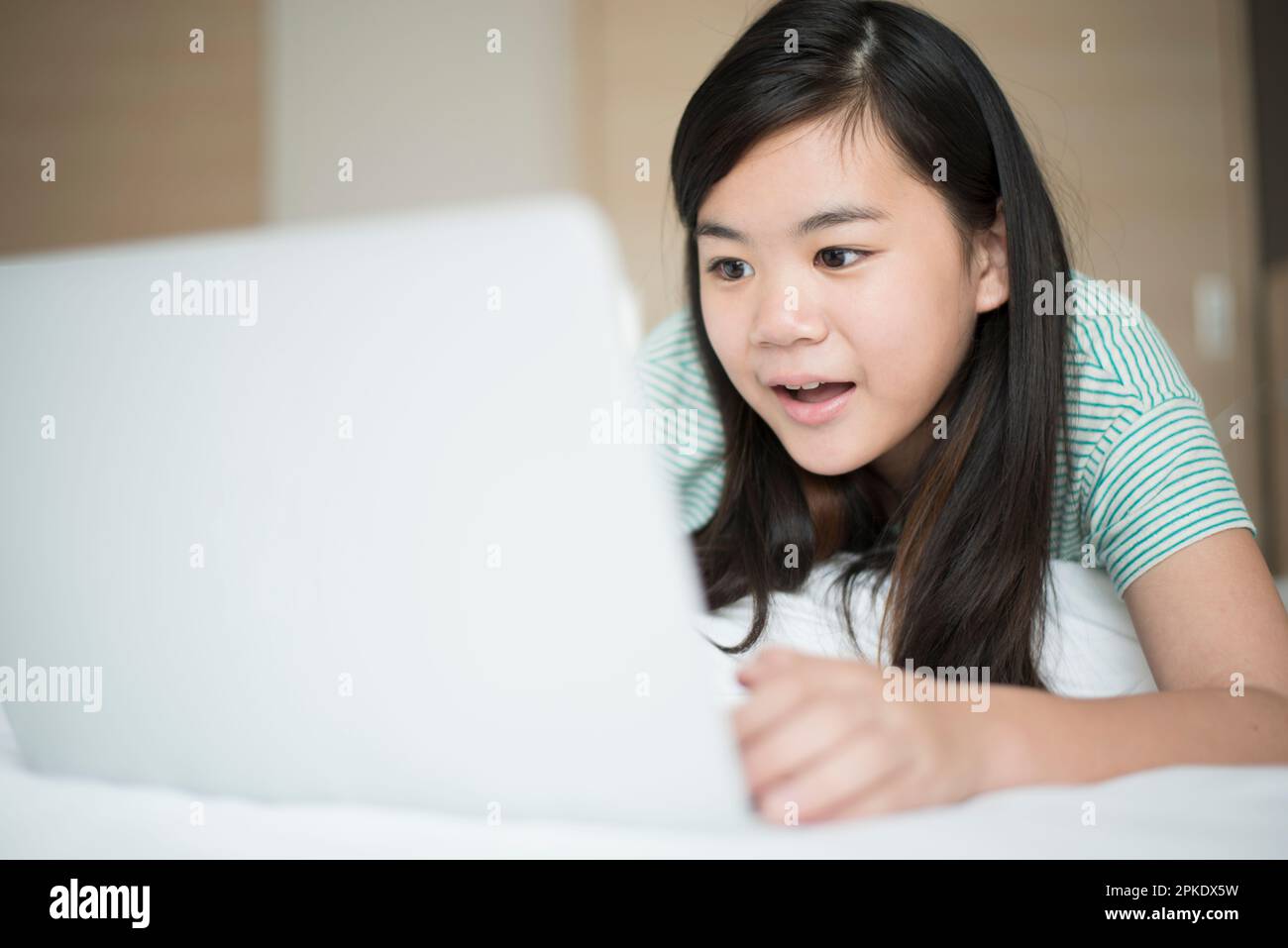 Girl looking at the computer and being surprised Stock Photo - Alamy