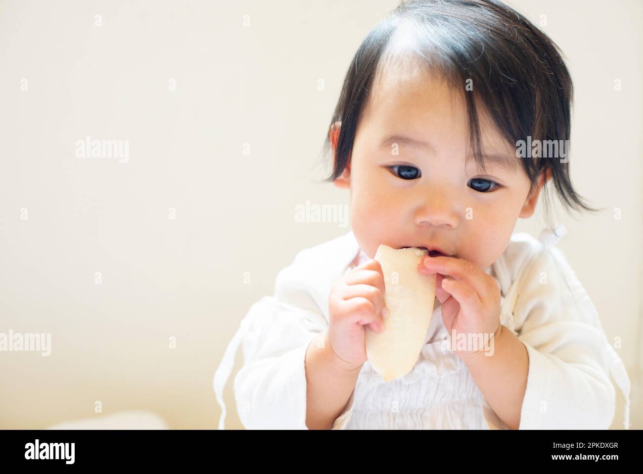 Baby eating rice cracker Stock Photo - Alamy