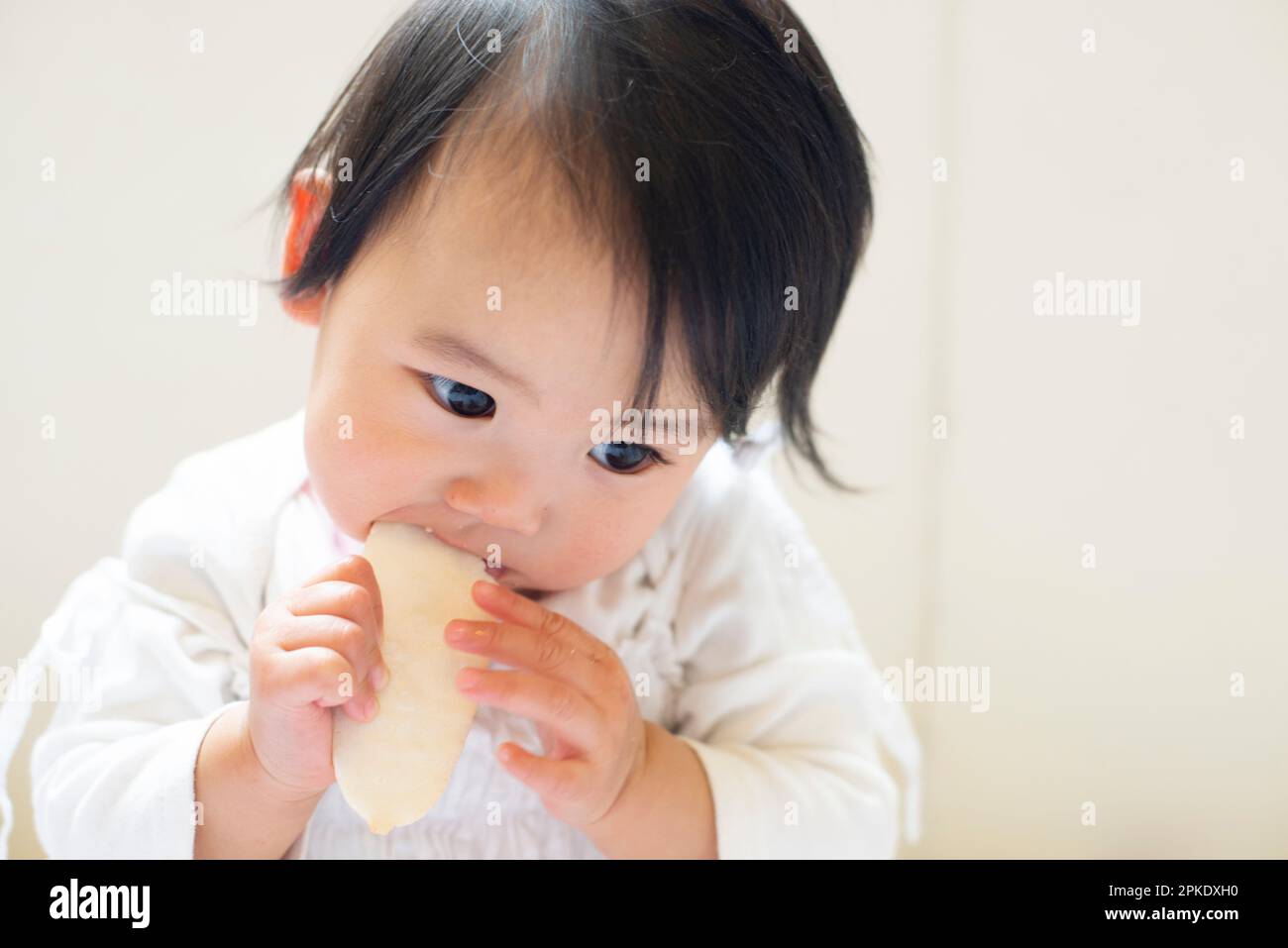 Baby eating rice cracker Stock Photo - Alamy