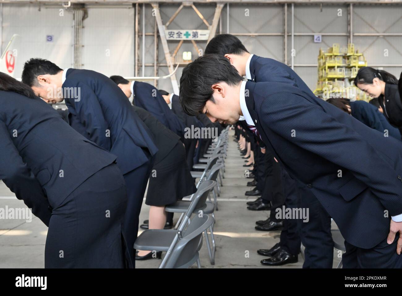 New employees attend the JAL Group entrance ceremony held in a hangar ...