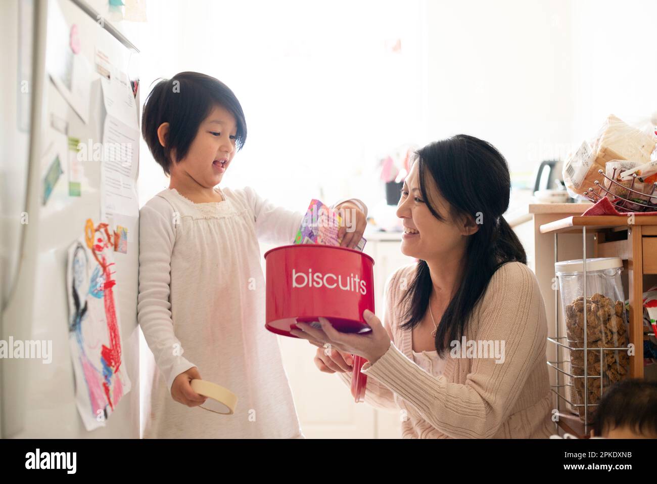 Parent and child touching a box of cookies Stock Photo - Alamy