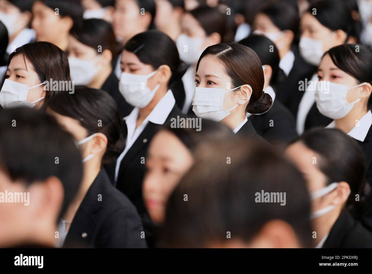 New employees attend the JAL Group entrance ceremony held in a hangar ...