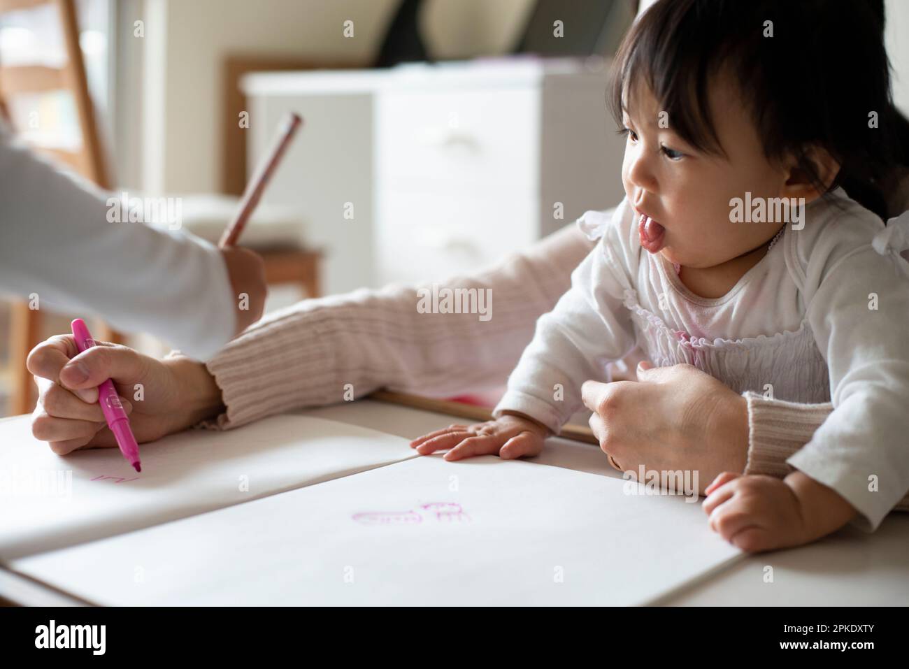 Parent and child drawing in the living room Stock Photo - Alamy