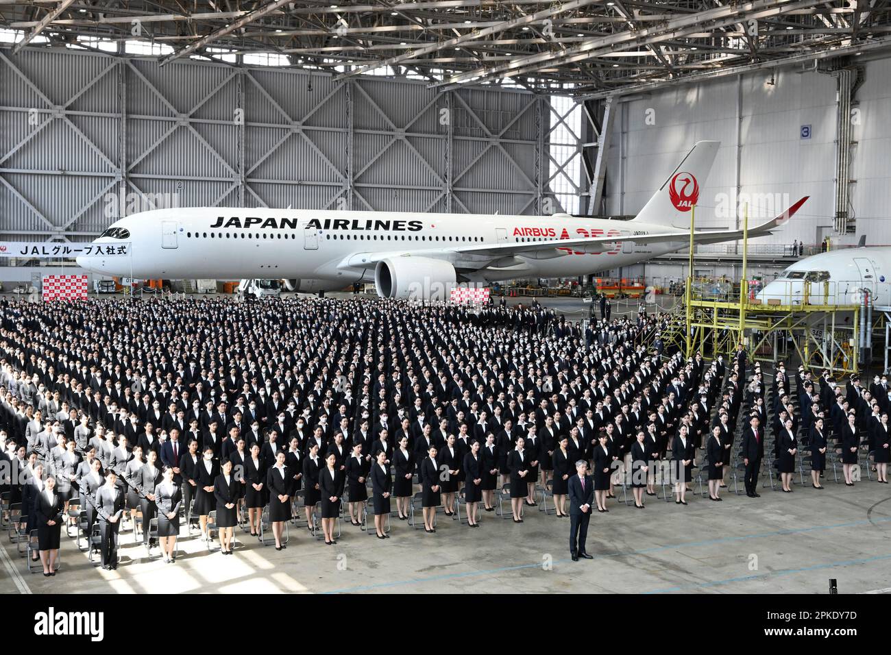JAL President Yuji Akasaka and new employees pose for a commemorative ...