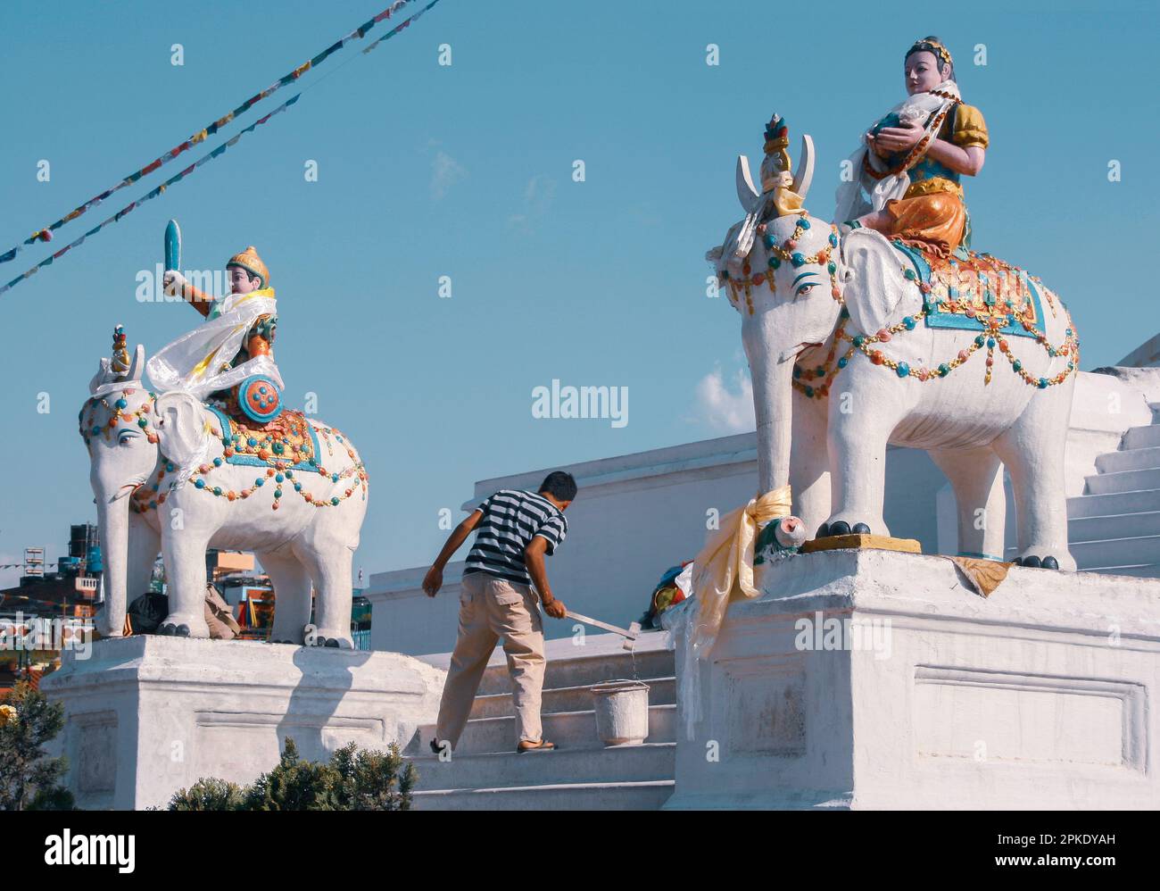 Nepalese man whitewash painting elephant statues at Boudhanath Stupa ...