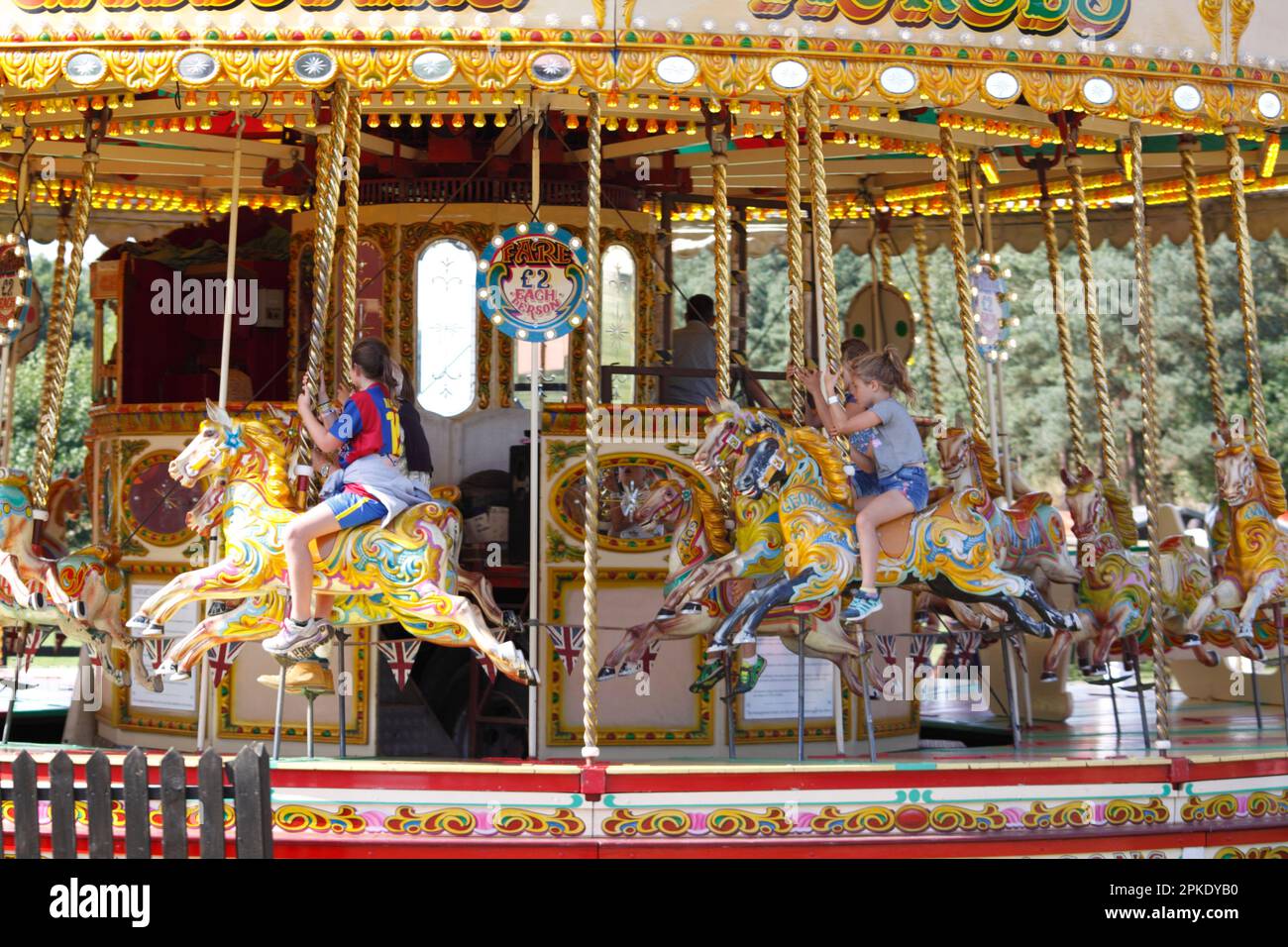 Fairground Carousel Horses with Children enjoying the Ride Stock Photo ...