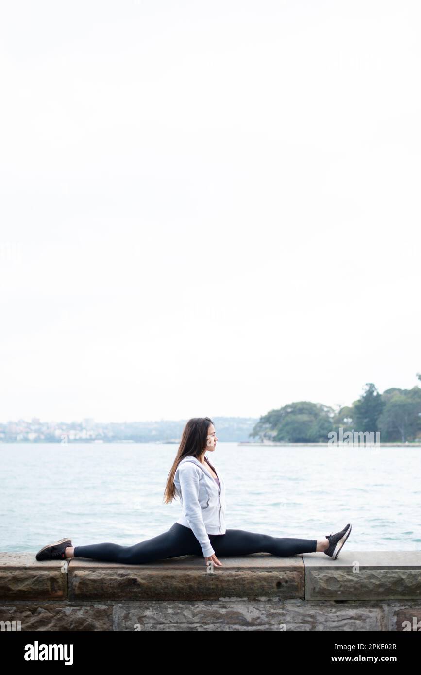 Woman stretching by the water Stock Photo - Alamy