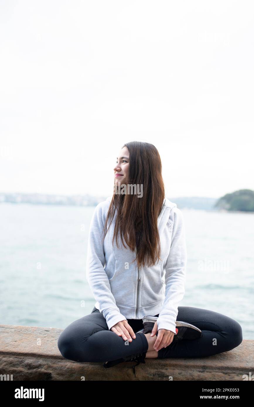 Woman sitting cross-legged and smiling Stock Photo - Alamy
