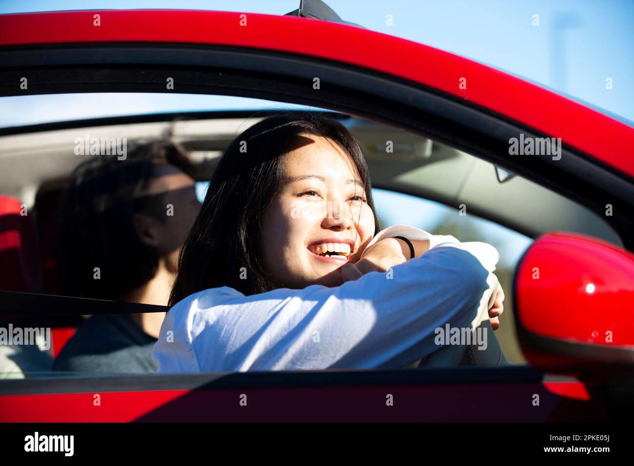 Woman laughing in the driver's seat of a car Stock Photo - Alamy
