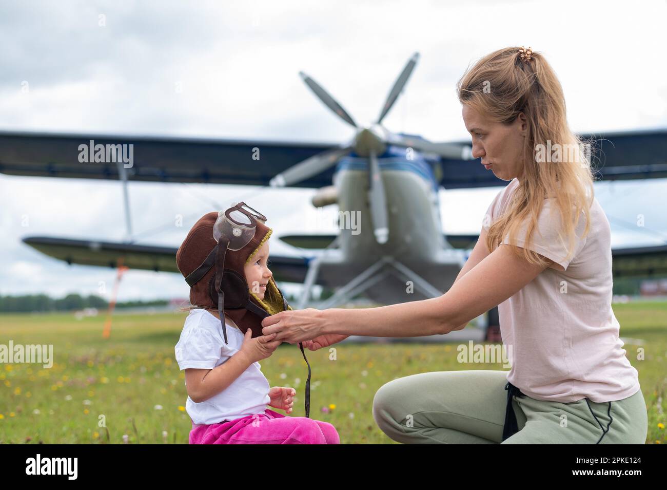A Caucasian woman and her little daughter are playing a pilot against ...