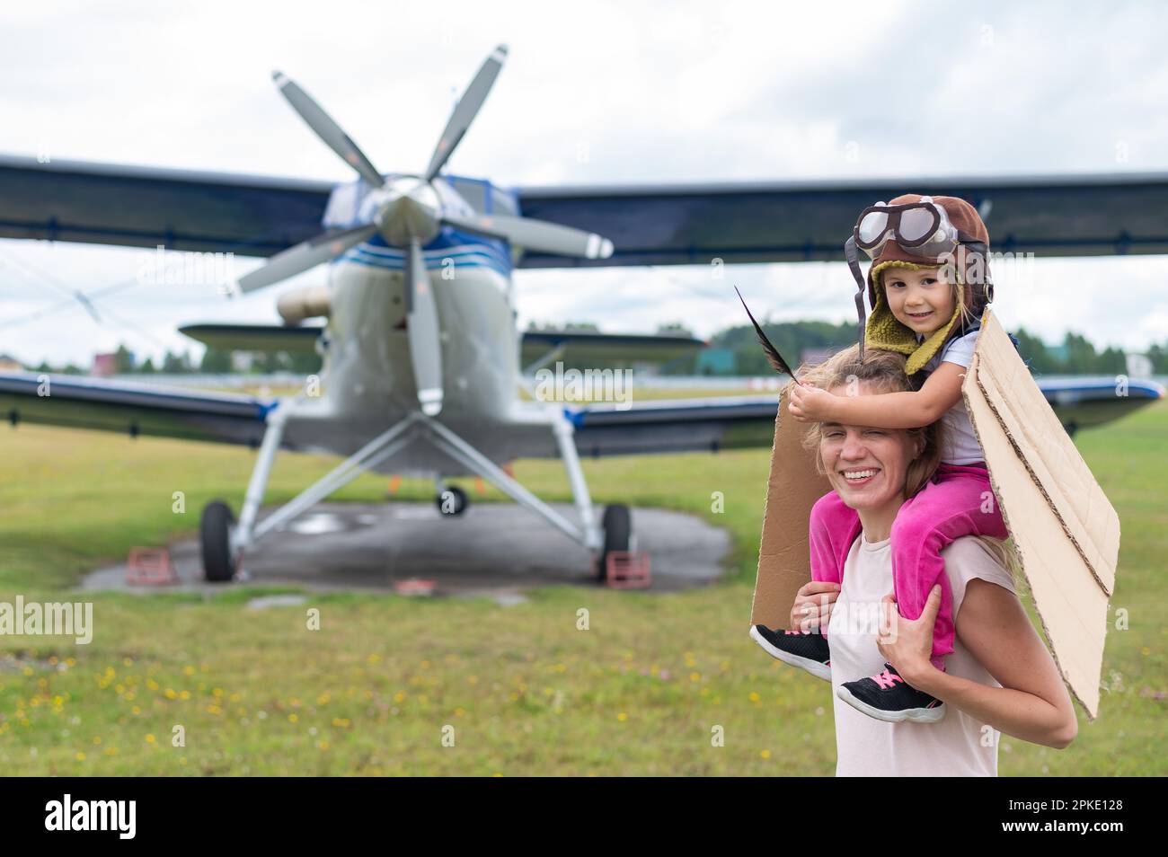 A Caucasian woman and her little daughter are playing a pilot against ...