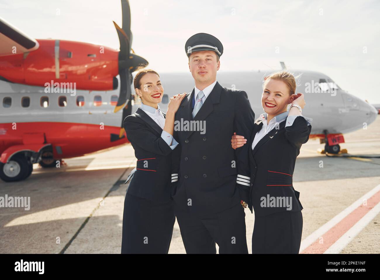 Pilot and two stewardesses. Crew of airport and plane workers in formal ...