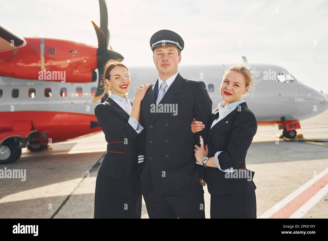 Pilot and two stewardesses. Crew of airport and plane workers in formal ...
