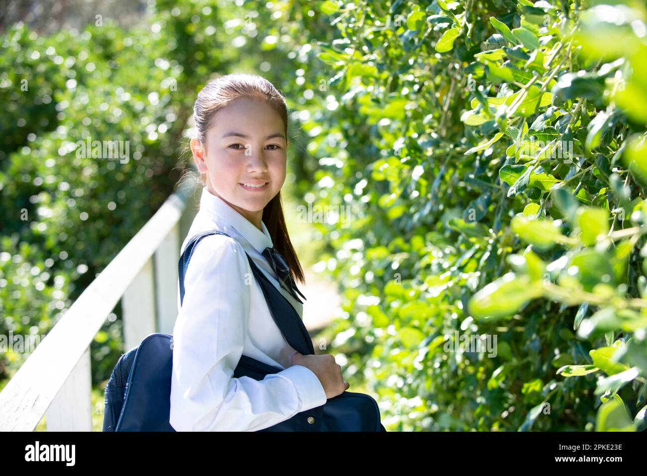 Schoolgirl in school uniform looking back Stock Photo - Alamy