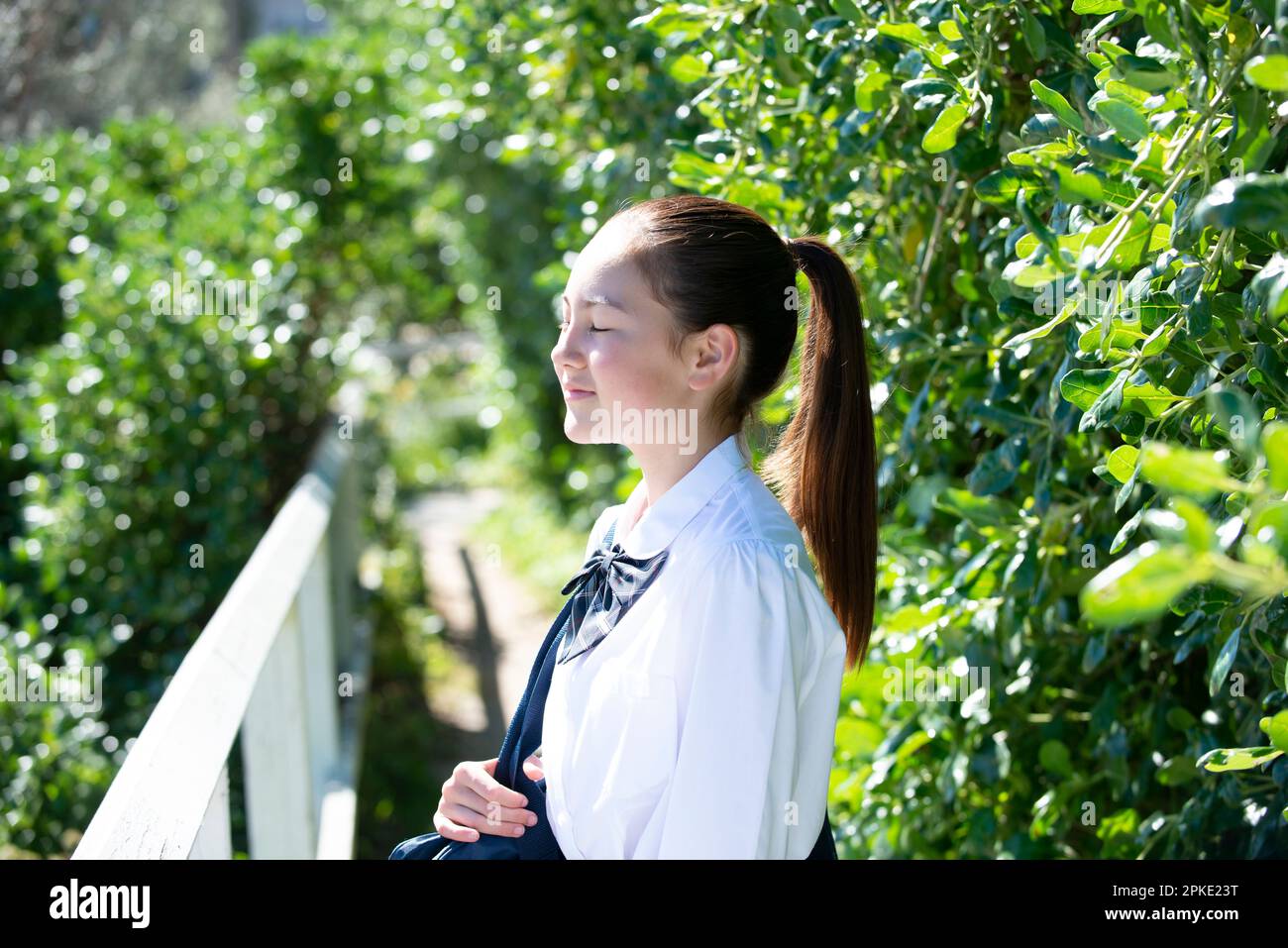 Female student in school uniform with eyes closed Stock Photo - Alamy