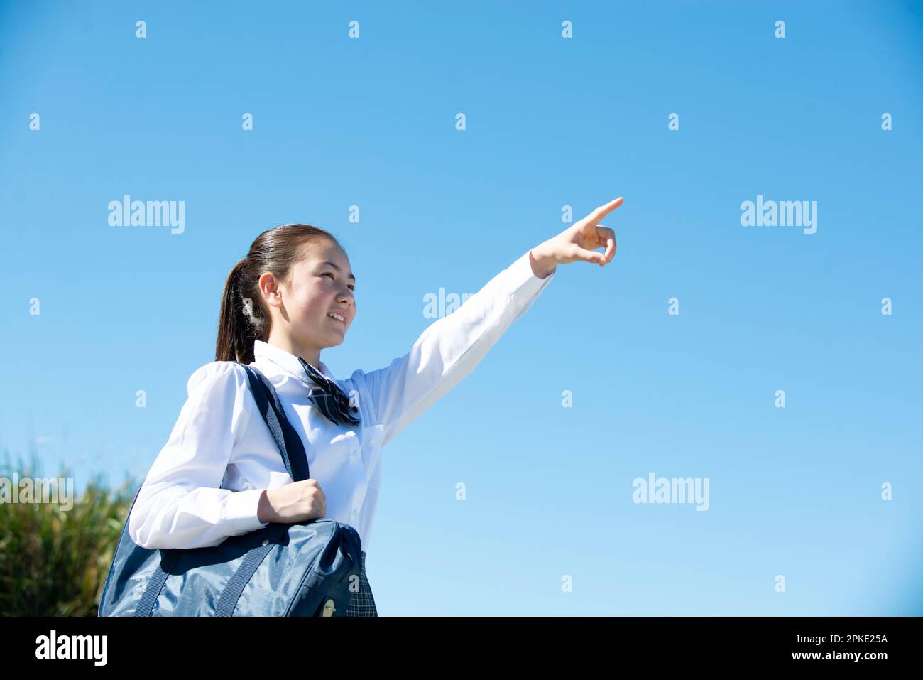 Female student in school uniform pointing into the distance Stock Photo ...