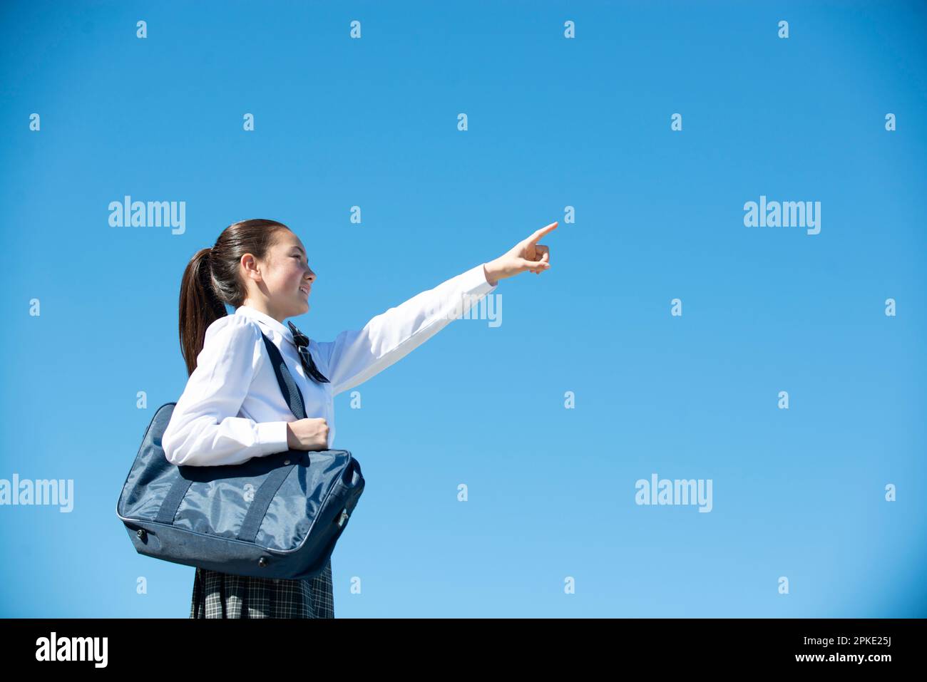 Female student in school uniform pointing in the distance Stock Photo ...