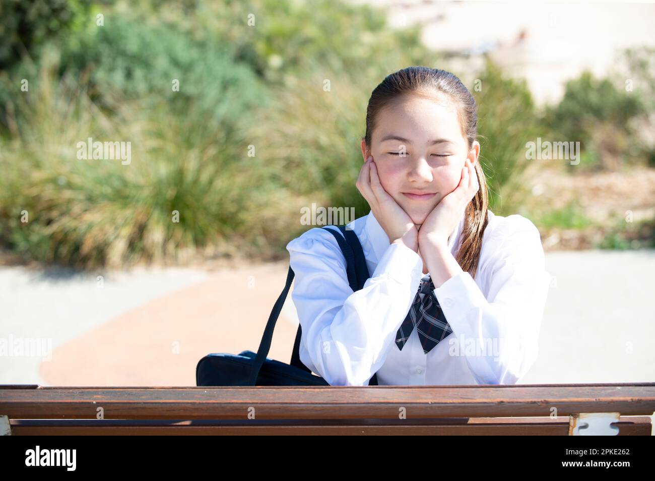 Female student in school uniform with cheekbones and eyes closed Stock ...