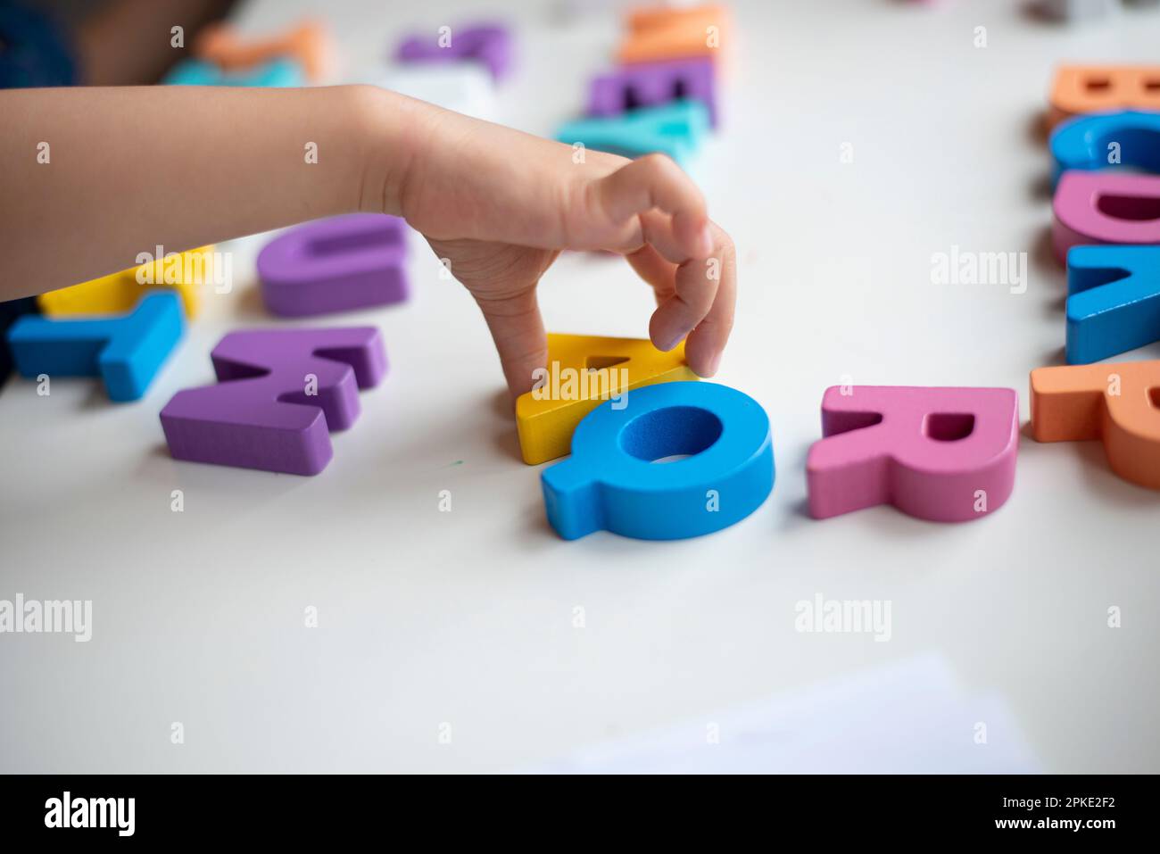 Child playing with wooden alphabet toy Stock Photo - Alamy