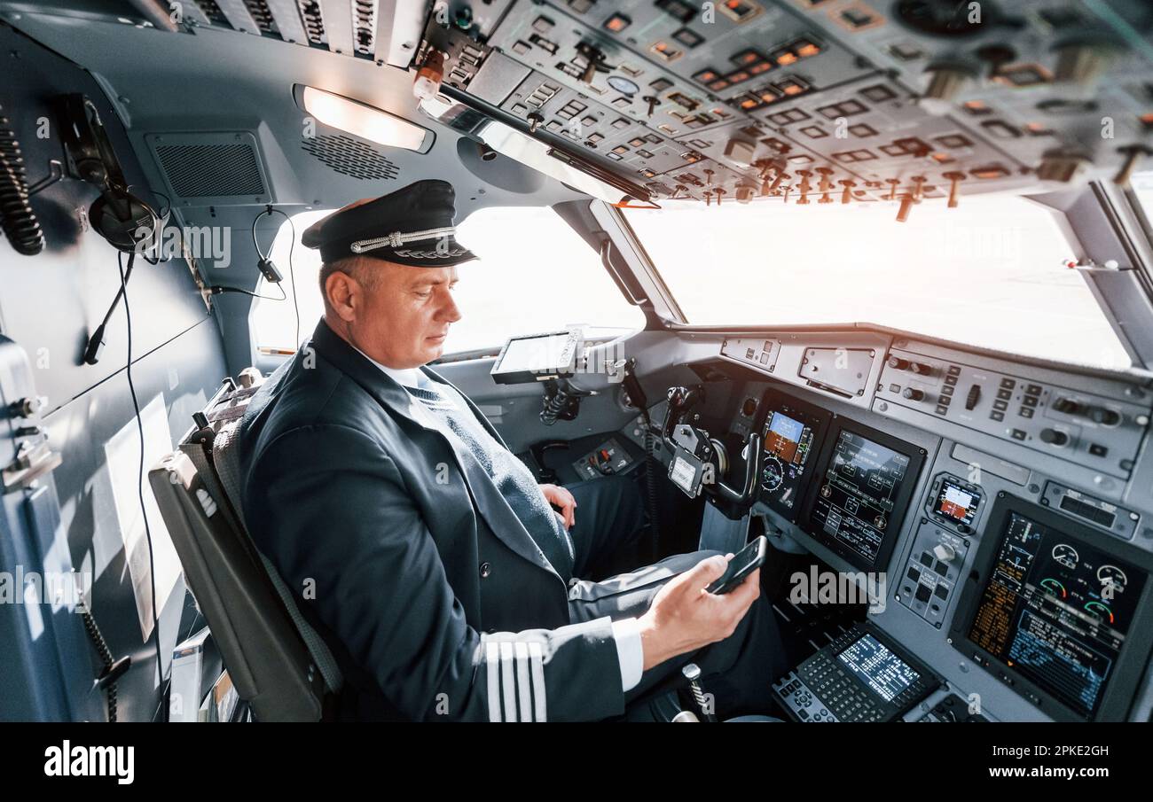 Side view. A professional pilot is in the cockpit. Conception of work ...