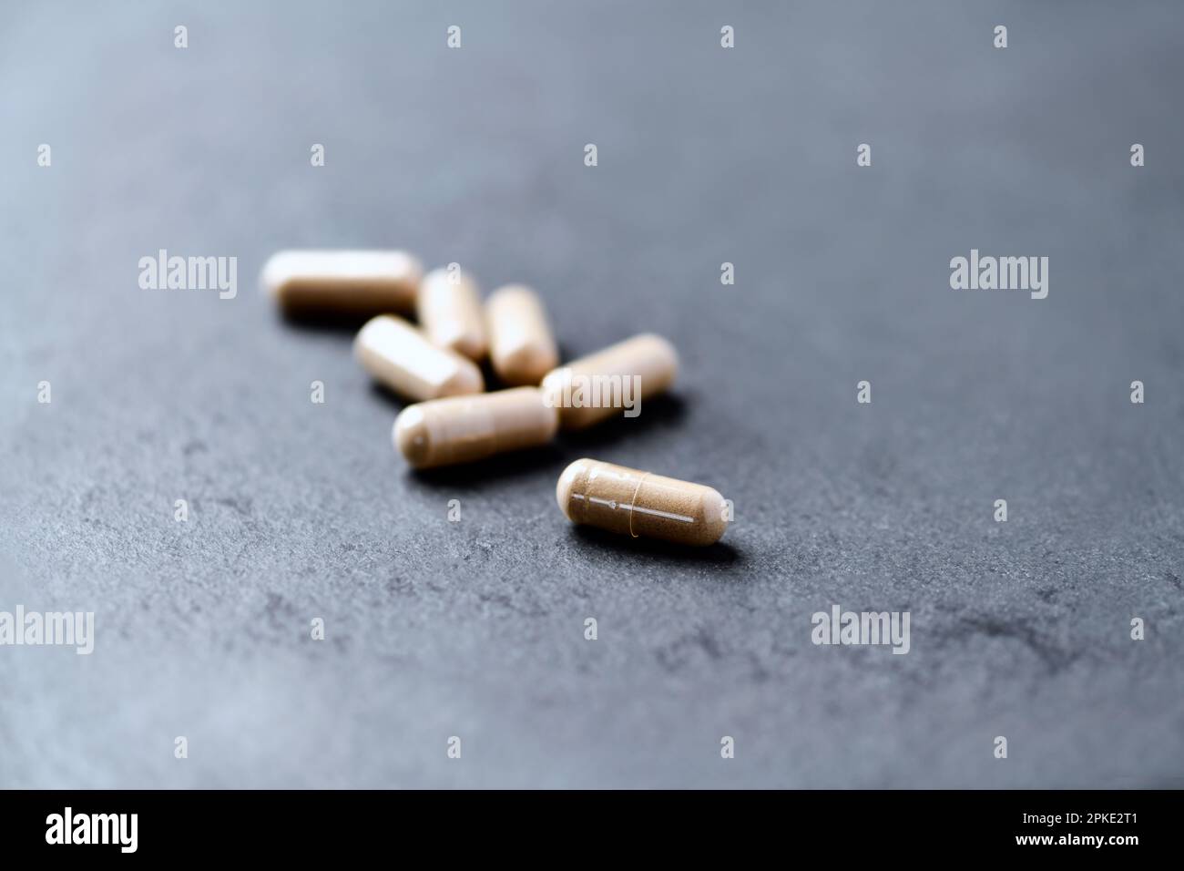 Ashwagandha (Withania somnifera) capsules. Dark stone background. Soft ...