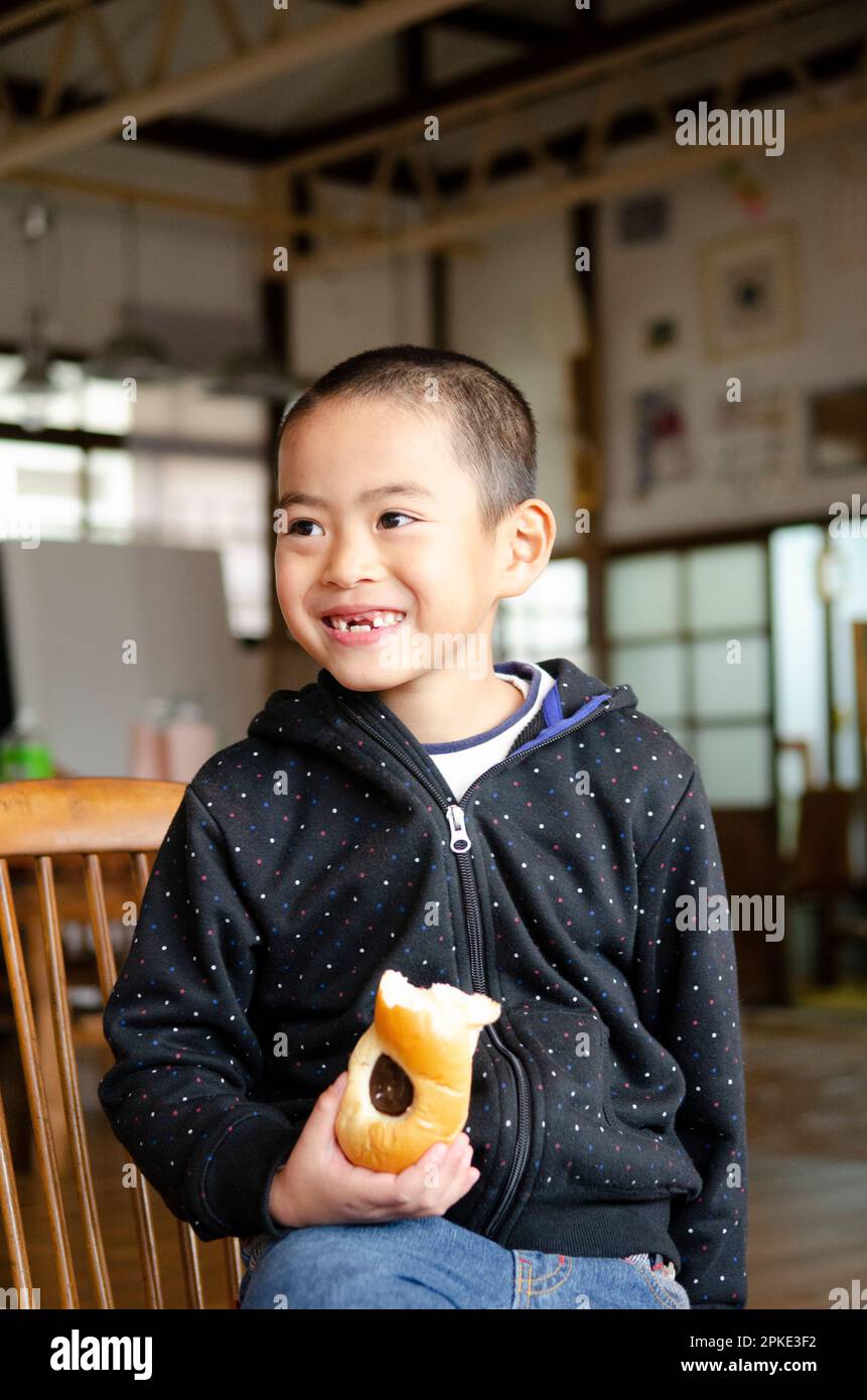 Toothless boy eating bread Stock Photo - Alamy
