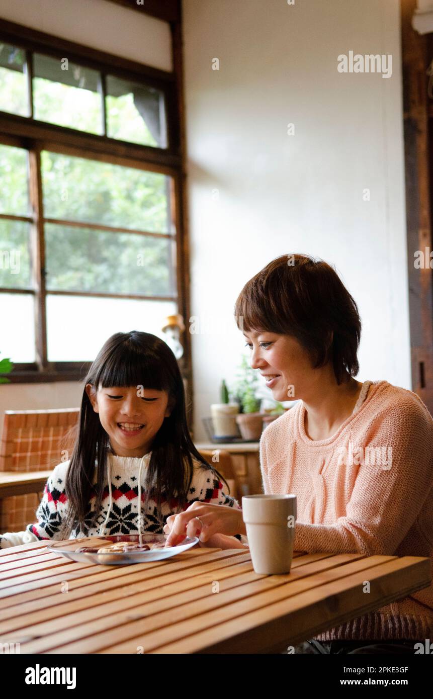Parent and child eating a snack Stock Photo - Alamy