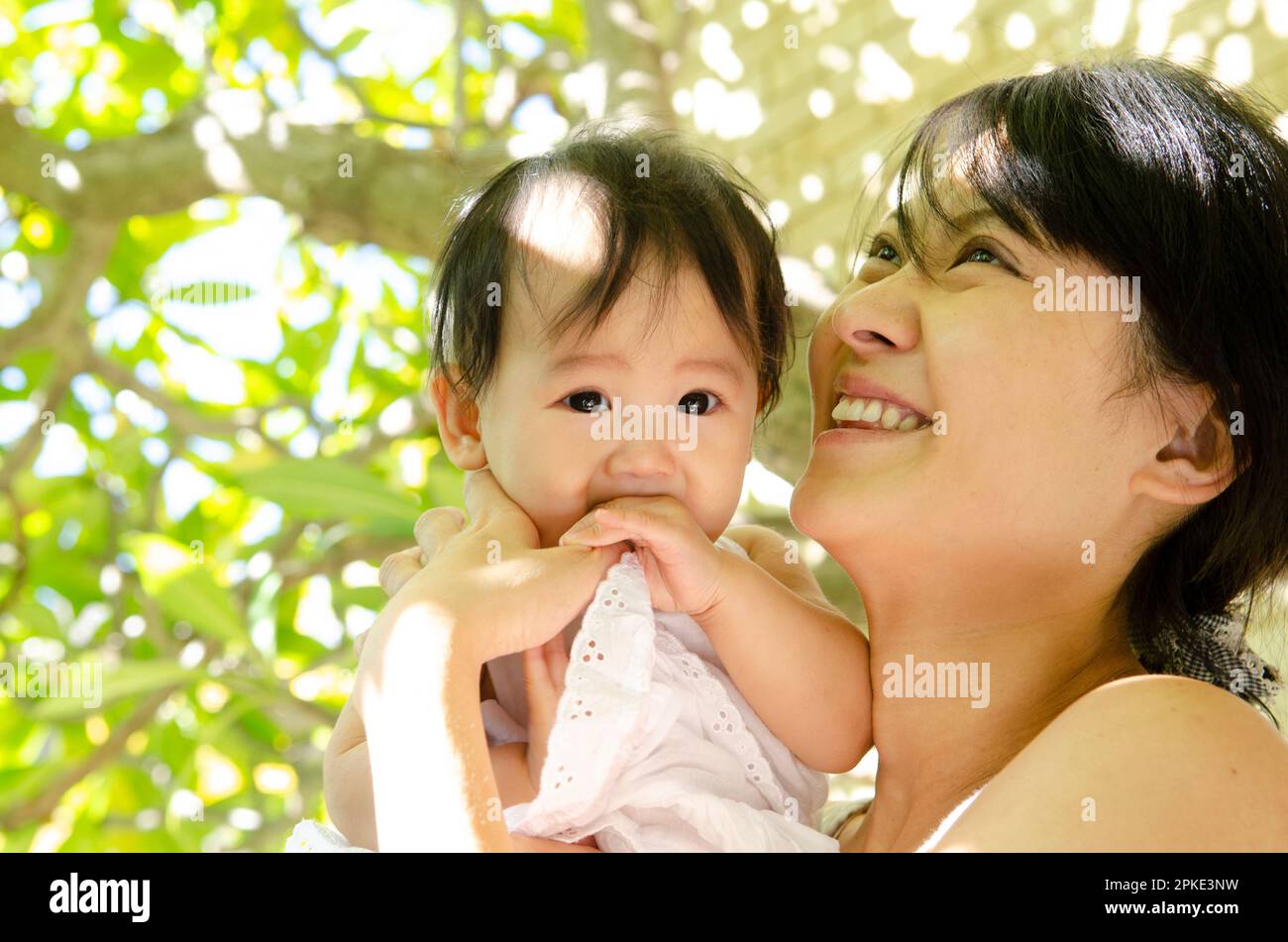 Baby and mother being carried under a tree Stock Photo - Alamy
