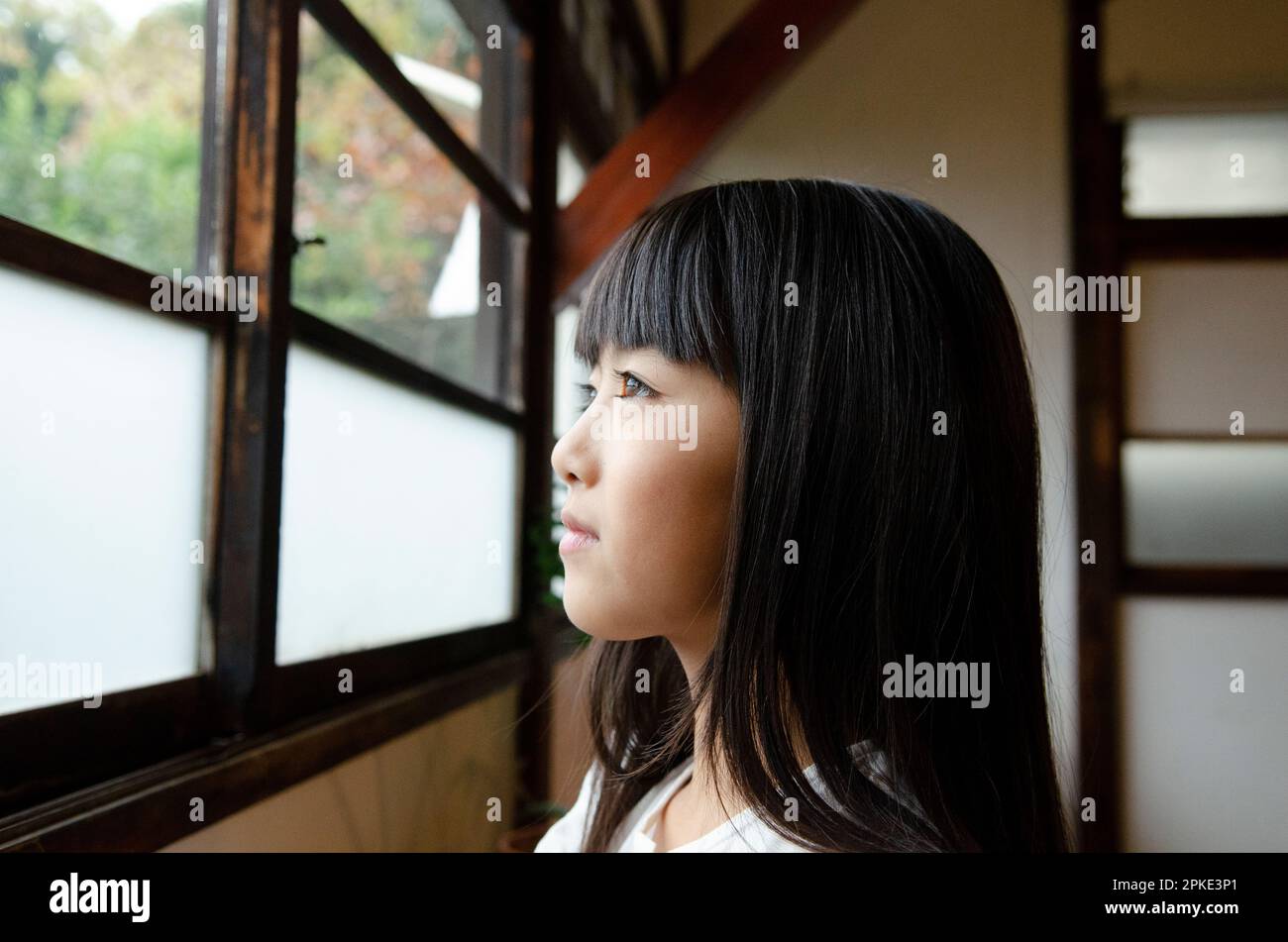 Girl looking out of window in profile Stock Photo - Alamy