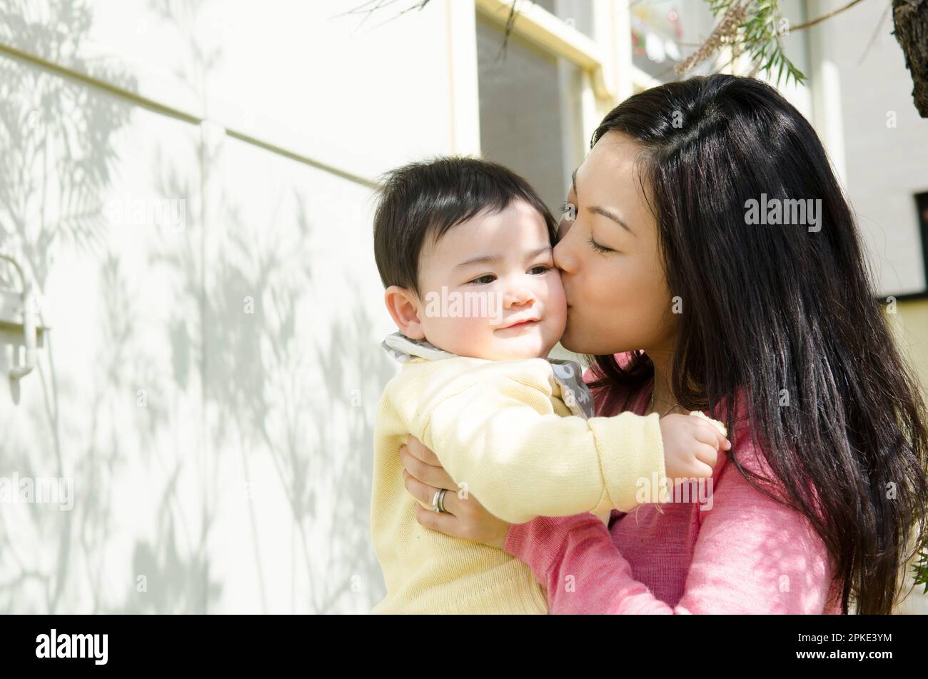 Mother kissing her child on the cheek Stock Photo - Alamy